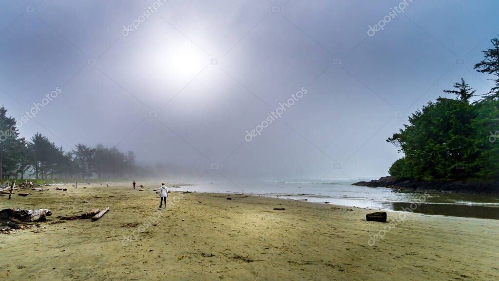 Gente caminando en la playa Sandy Beach de Cox Bay en Dense Fog ...