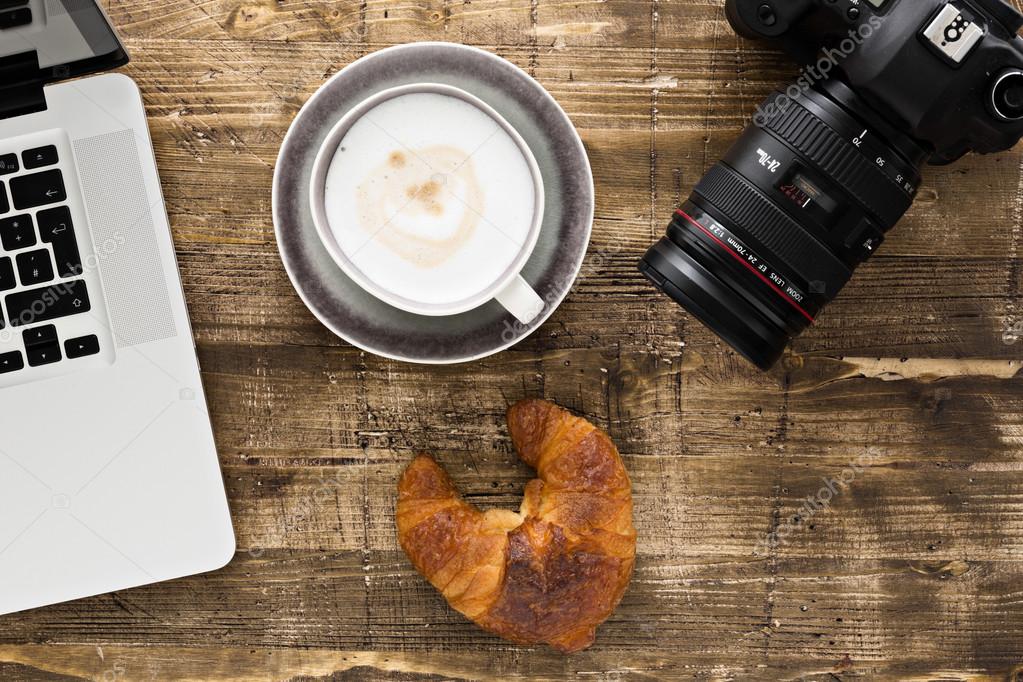 Laptop, camera, coffee and croissant on a wooden table Stock Photo by ...