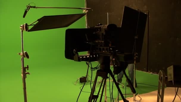 Professional grip on a film set sets up a stand and walks off frame ...