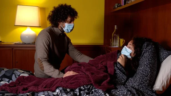 husband looking after sick wife while she lying in bed at home ...