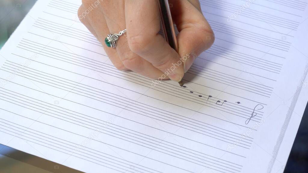 músico compositor niña mano escribe música con notas en la hoja de ...
