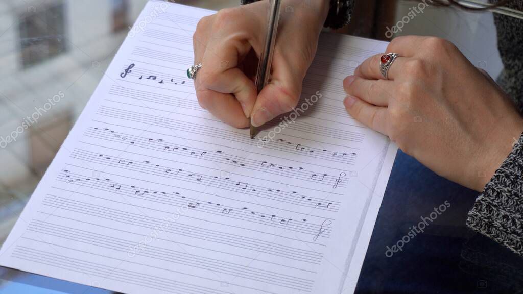 músico compositor niña mano escribe música con notas en la hoja de ...