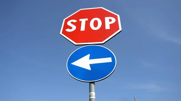 Stop sign on the road in a blue sky - only one direction possible ...