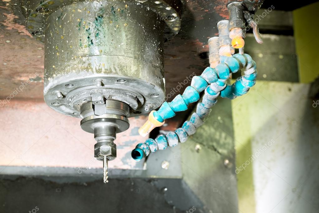 A CNC milling machine milling heads in metal industry with coolant ...