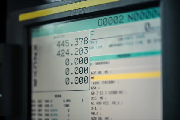 CNC machine monitor display with program code running and numbers with ...