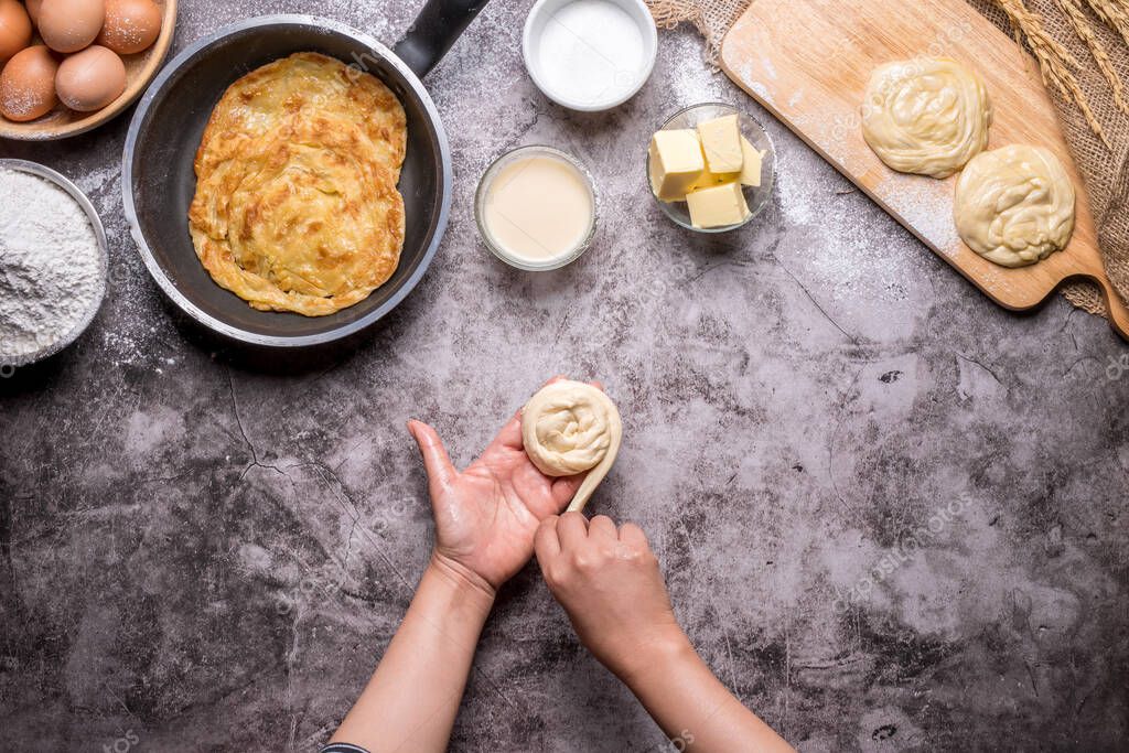 Una imagen de la mano de un cocinero amasando masa para hacer Roti, una ...