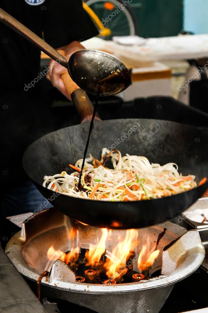 comida callejera. fideos fritos en un wok con pollo y gambas 2022