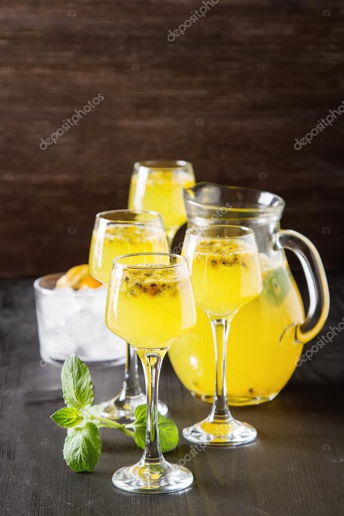 Cóctel alcohólico con fruta fresca de la pasión con menta y hielo. D) 2024