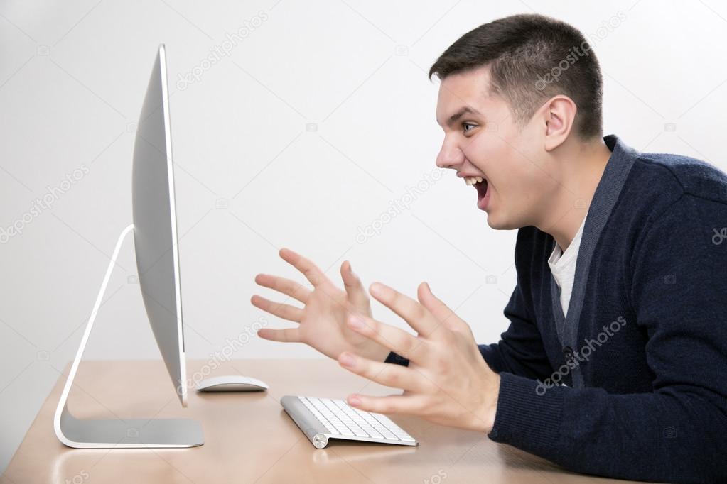 Angry man yelling on computer screen Stock Photo by ©AlexBrylov 71514471
