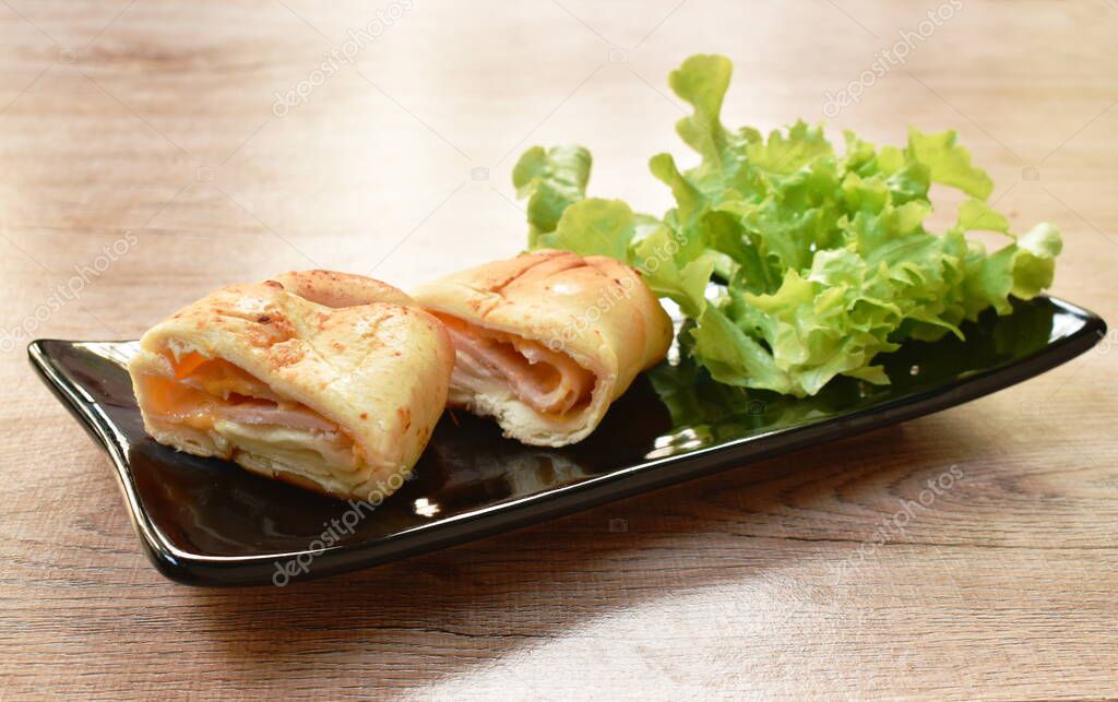 pan rebanada de jamón relleno de cerdo y queso con verduras en el plato ...