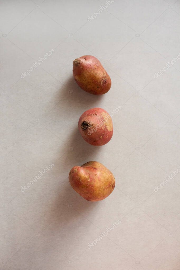 Tres patatas graciosas sobre un fondo gris claro. Hortalizas y frutas ...