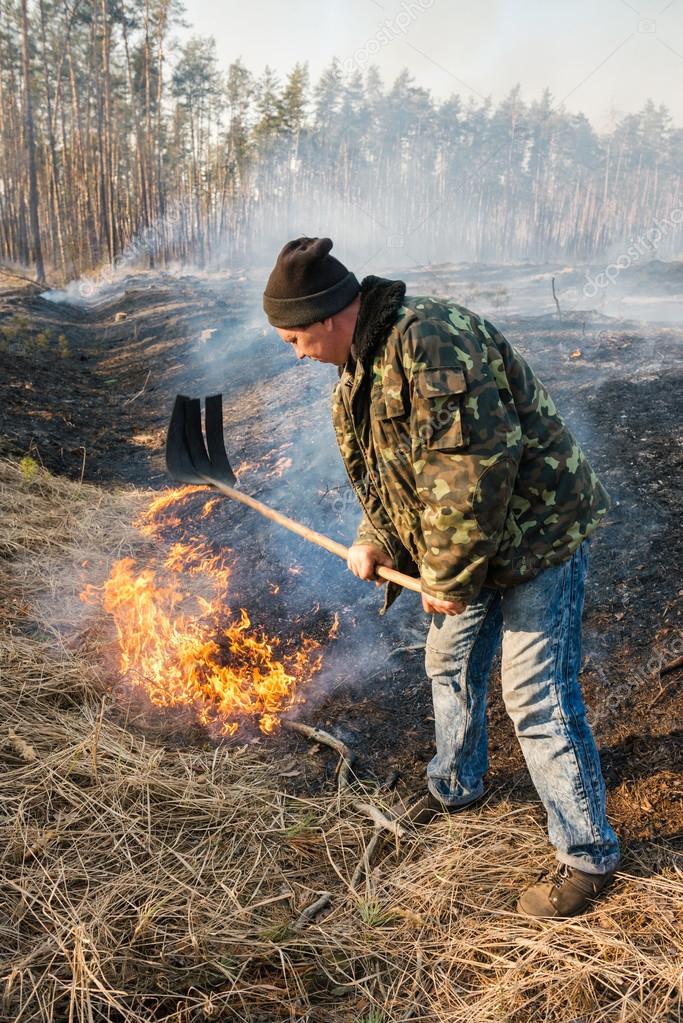 Firefighter use leafs branch for forest fire suppression – Stock ...