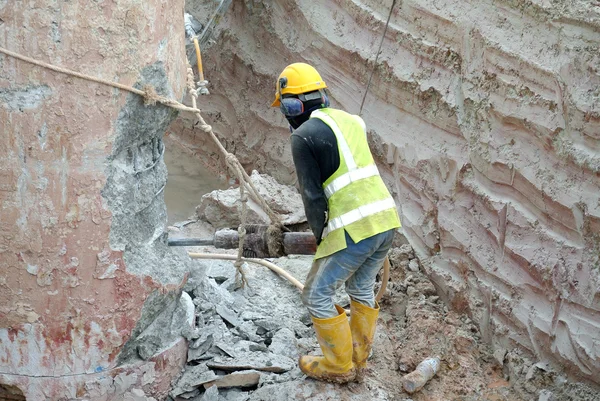 Construction workers using mobile concrete hacker at the construction ...