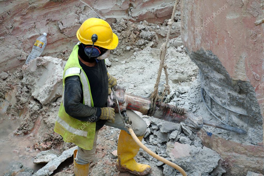 Construction workers using mobile concrete hacker at the construction ...