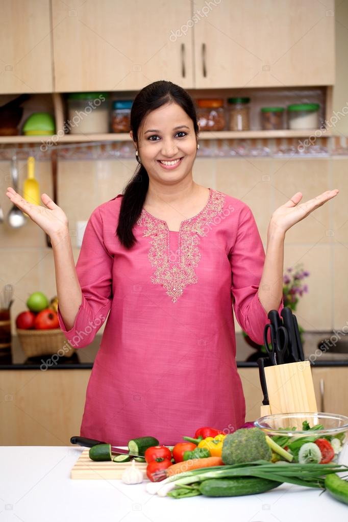 Smiling young Indian woman in her kitchen Stock Photo by ...