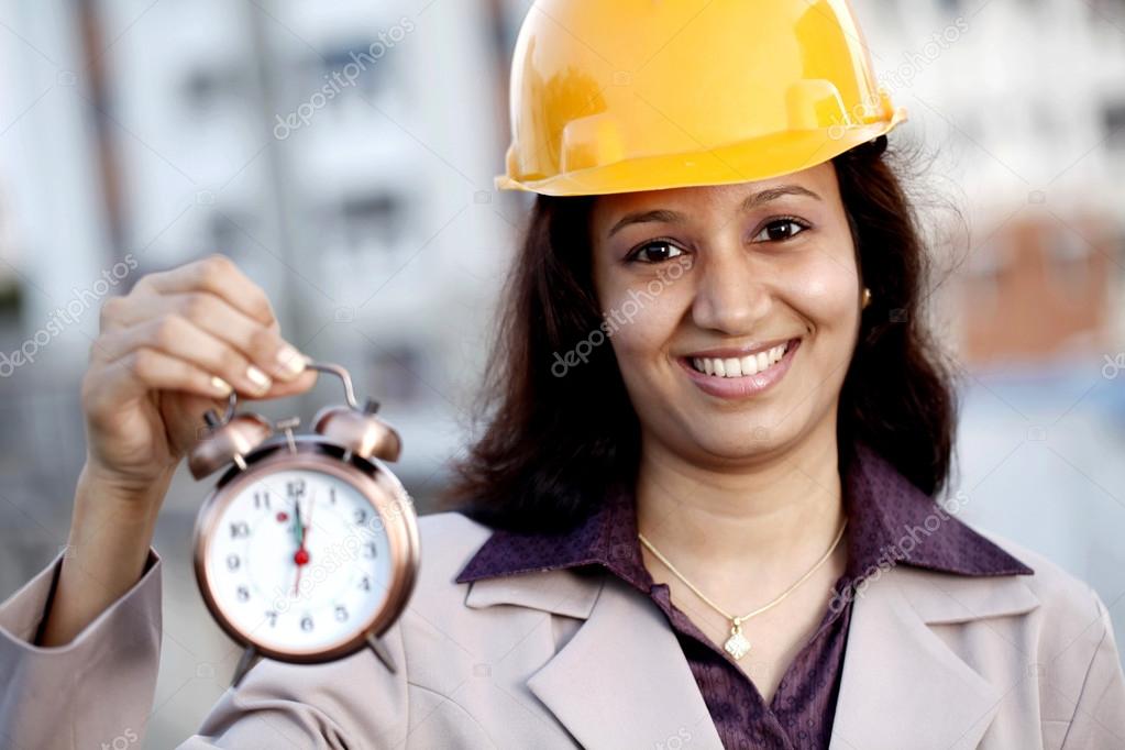 Female construction engineer holding alarm clock — Stock Photo ...