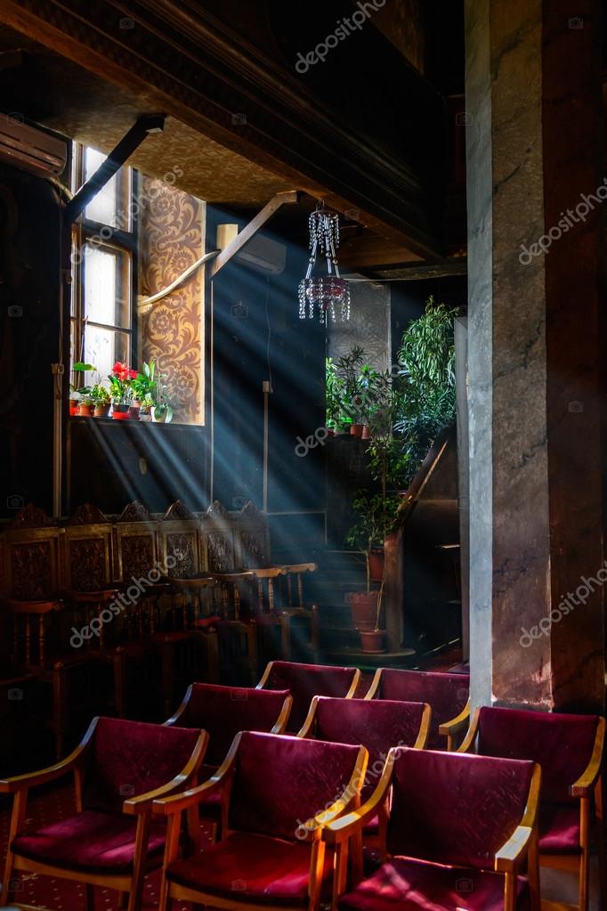 Sun rays over church window inside. A dim old church interior li ...
