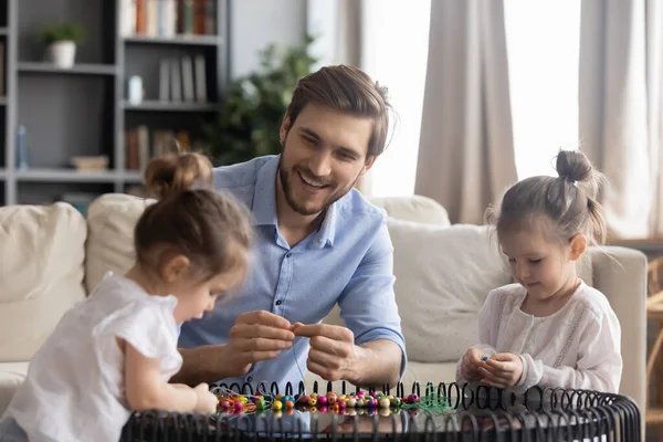 Loving dad engaged in creative activity with daughters - Stock Image ...