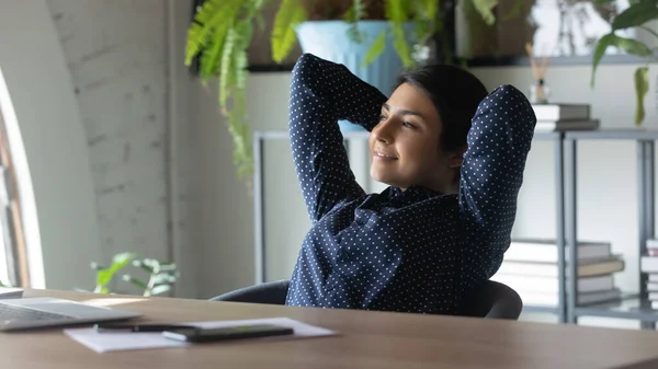 Indian ethnicity millennial employee relaxing in workplace completed ...