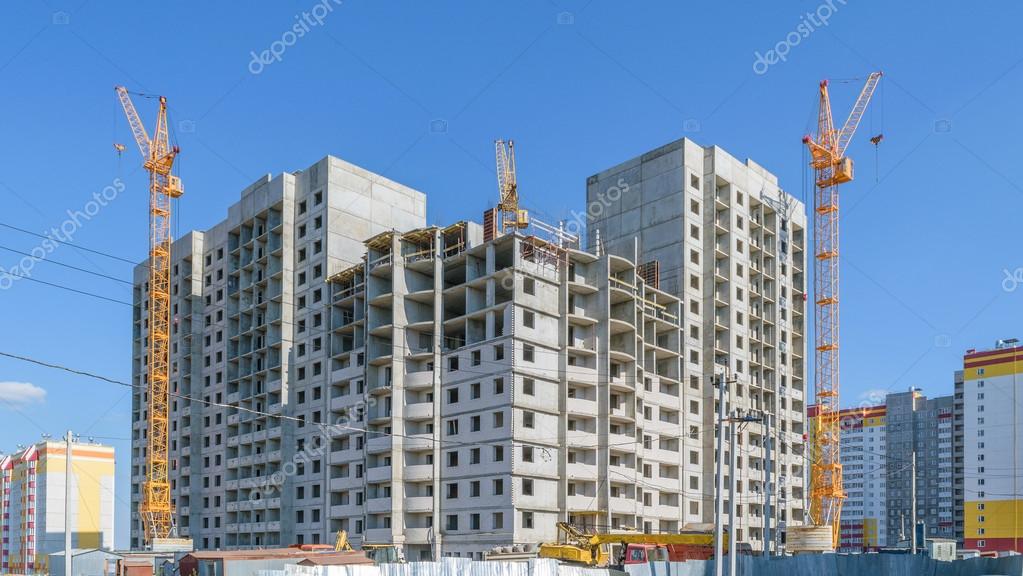 Construction of new multi-storey panel house. Three tower cranes ...