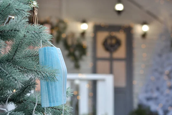 The medical mask weighs on the Christmas tree against the backdrop of ...