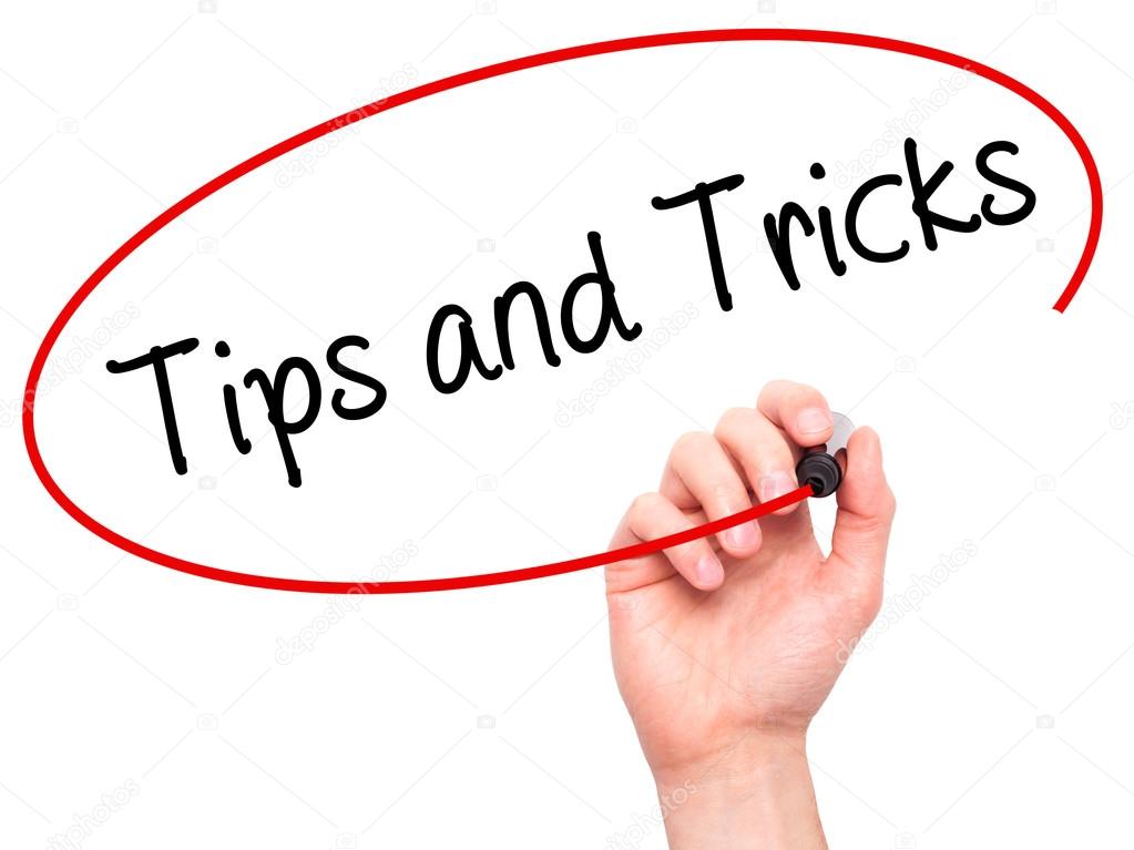 Man Hand writing Tips and Tricks with black marker on visual scr ...