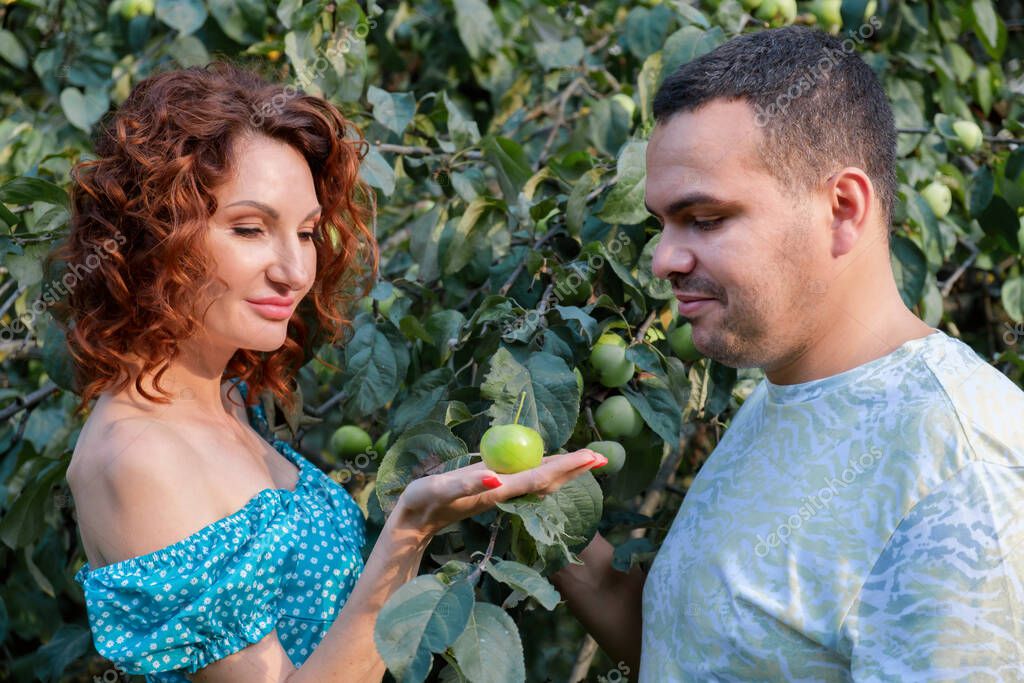 Mujer atractiva sosteniendo una manzana en la palma de la mano y se la ofrece al hombre de ...