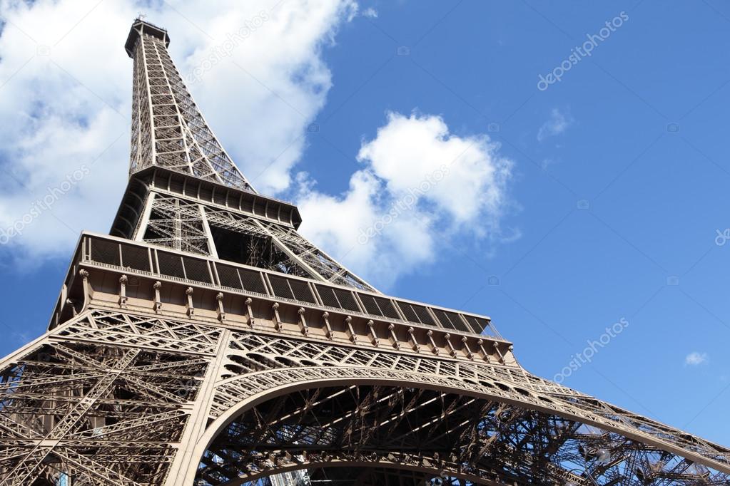 Wide low angle view of Eiffel Tower looking upwards into blue sk ...