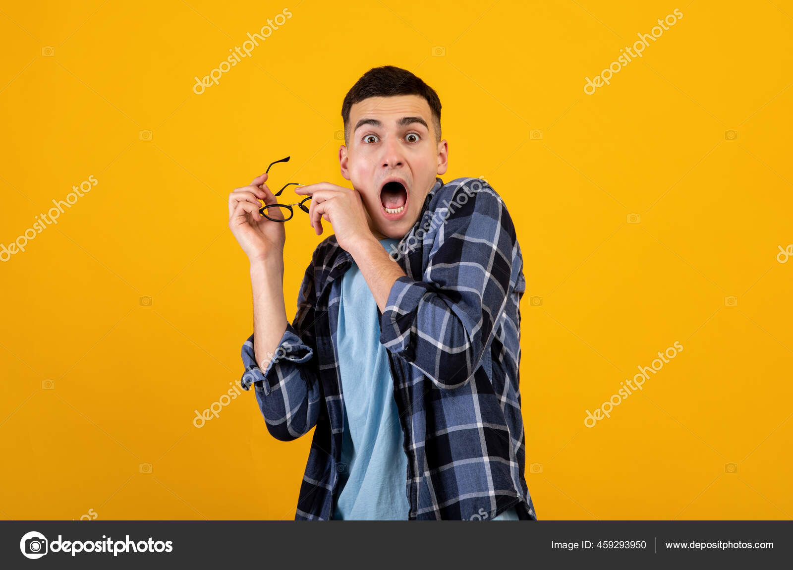 Horrified young guy yelling in panic, taking off his glasses over ...