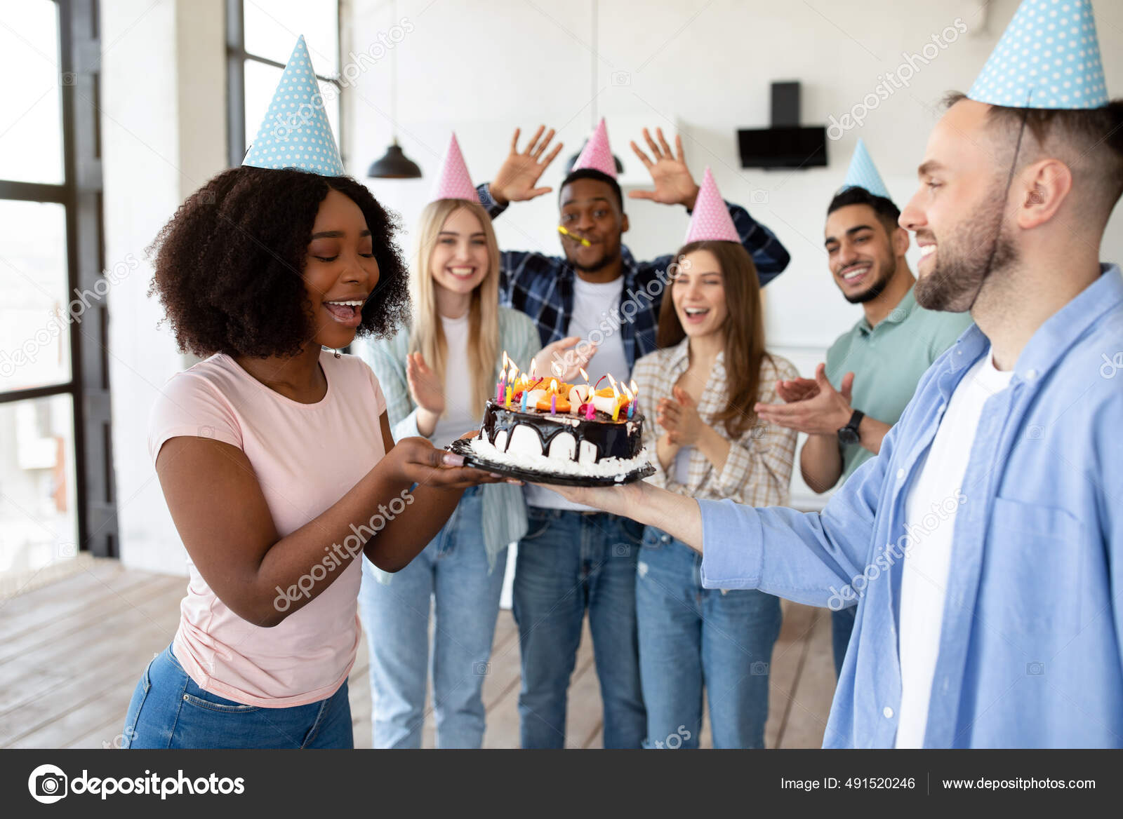 Group of cool multiethnic millennials celebrating birthday, presenting ...