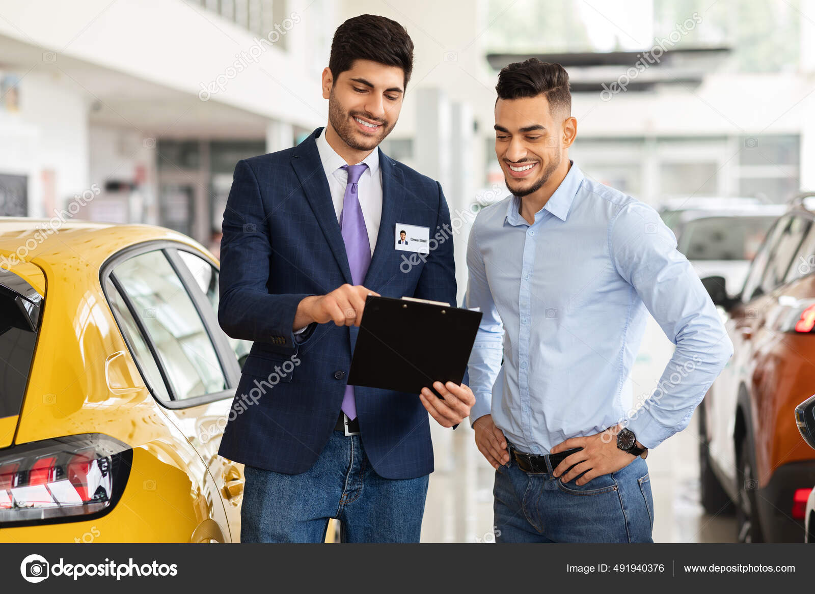 Handsome arab guy having conversation with sales assistant in showroom ...
