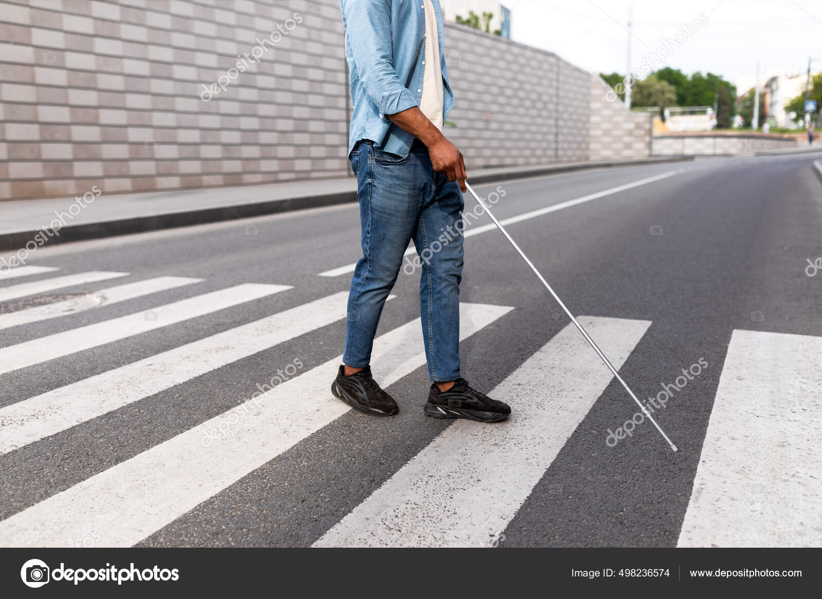 Irreconhecível jovem preto visualmente deficiente homem com cana ...