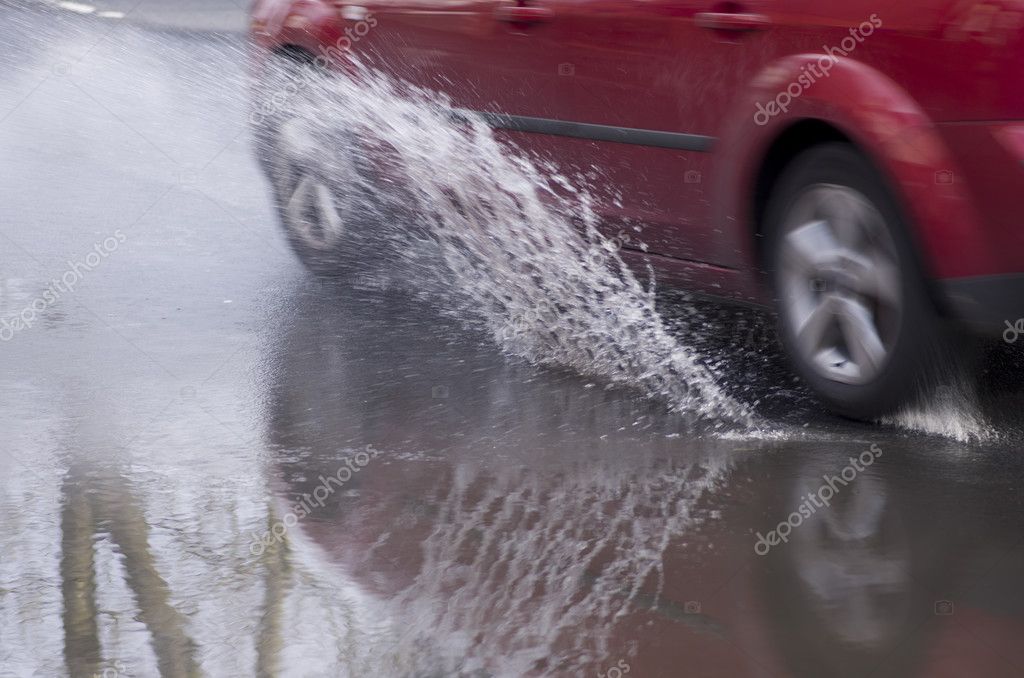Red car rides on big puddle. Water splash. — Stock Photo © marcinwos ...