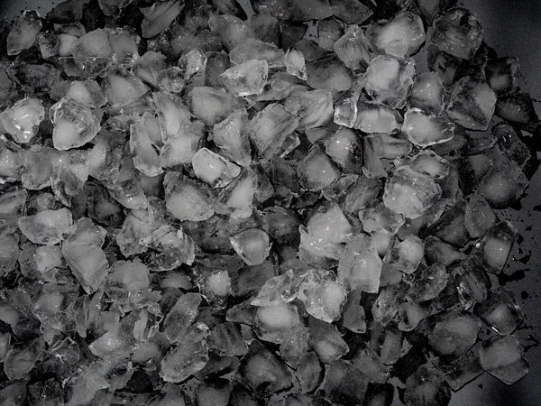 Texture, pattern, or wallpaper. Clean, white crushed (chipped) ice cubes on a black studio ...