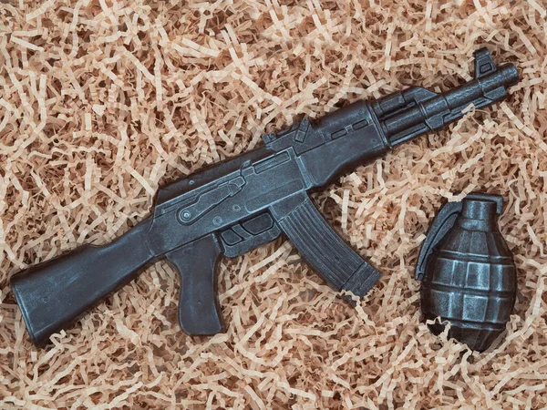 Food chocolate automatic rifle with an edible grenade in wood chips ...