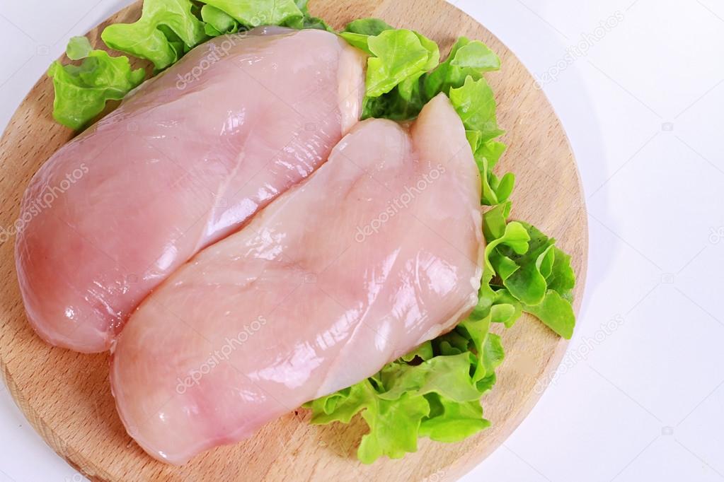 Filetes de pechuga de pollo crudo decorados con ensalada en tabla de ...