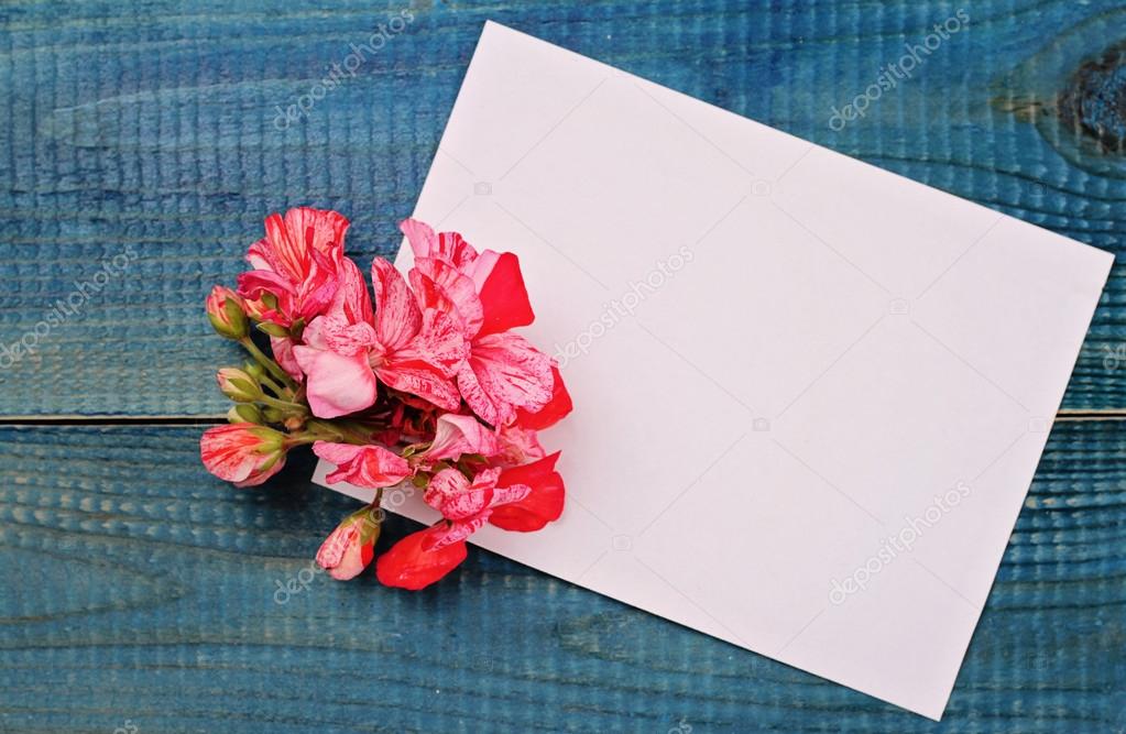 Blank message card and bouquet of flowers on blue wooden rustic table ...