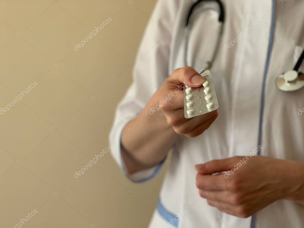 Primer plano es la mano de un médico sosteniendo una píldora para su ...