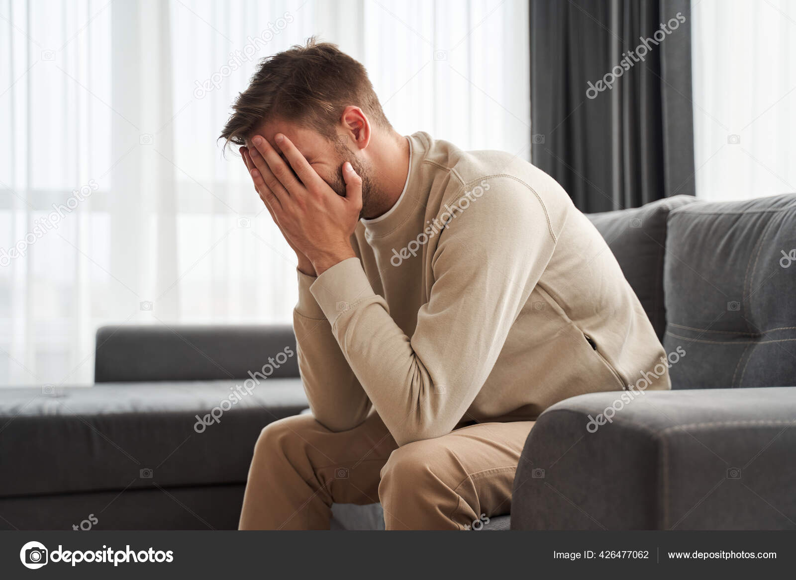 Sad man sitting on the sofa Stock Photo by ©iakovenko123 426477062