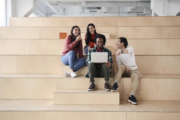 Four diverse classmates having fun and laughing out loud while prepare ...