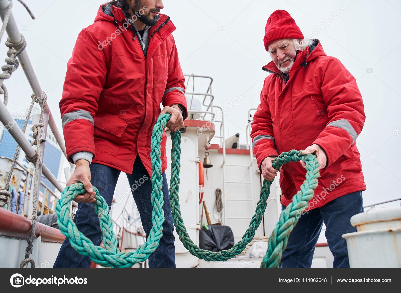 Fisherman and his colleague pulling rope on deck of a boat Stock Photo ...