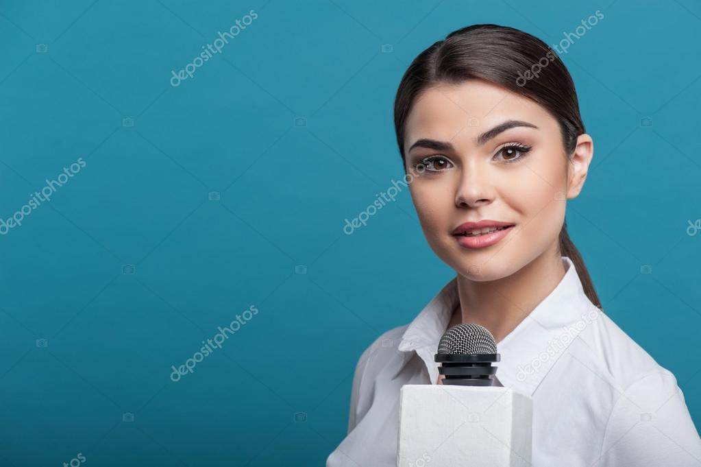 Beautiful girl TV journalist is interviewing and listening to someone ...