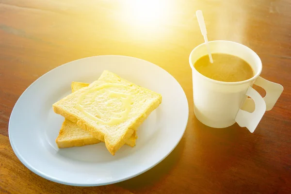 Hot coffee and bread toast topped with sweet milk for breakfast on wood ...
