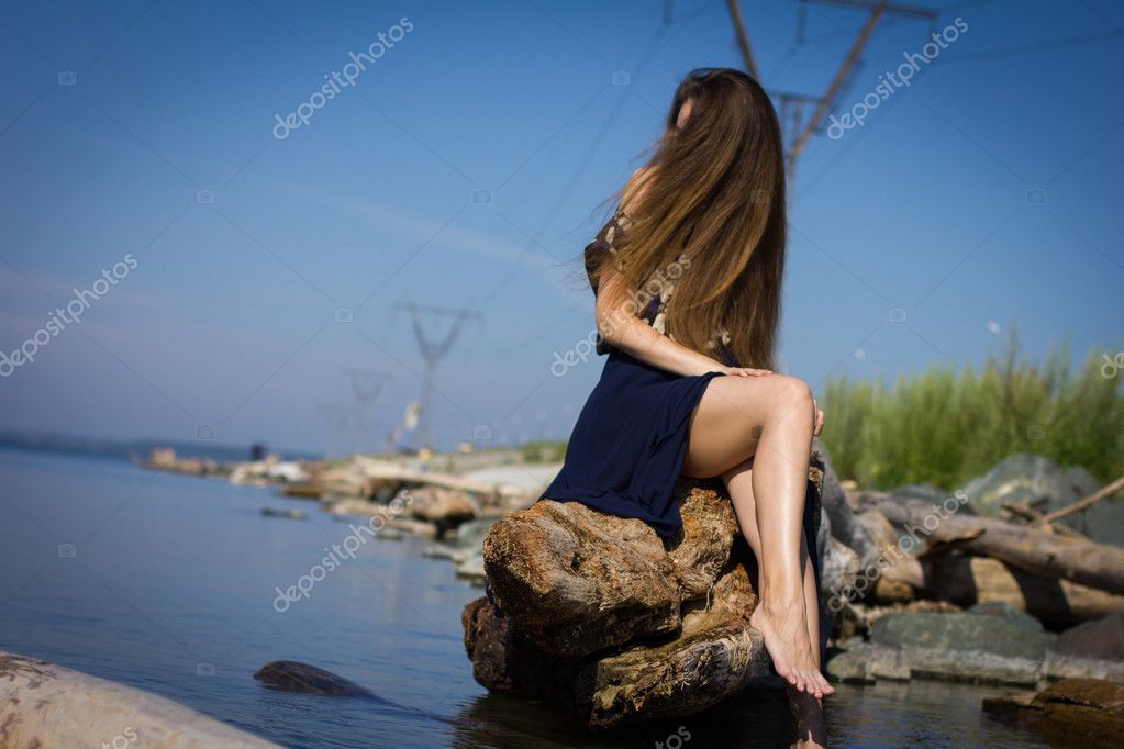 Chica en la playa en los troncos — Foto de stock #64824285 © Edinorog12