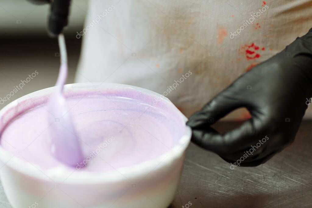 pastelero añade tinte morado y sabor a la crema para hacer pasteles y ...