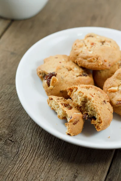Chocolate chip cookies on white disk on wooden table - Stock Image ...