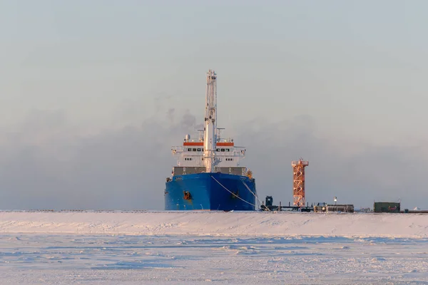 Cargo vessel moored in arctic port. Winter time. Ice navigation ...
