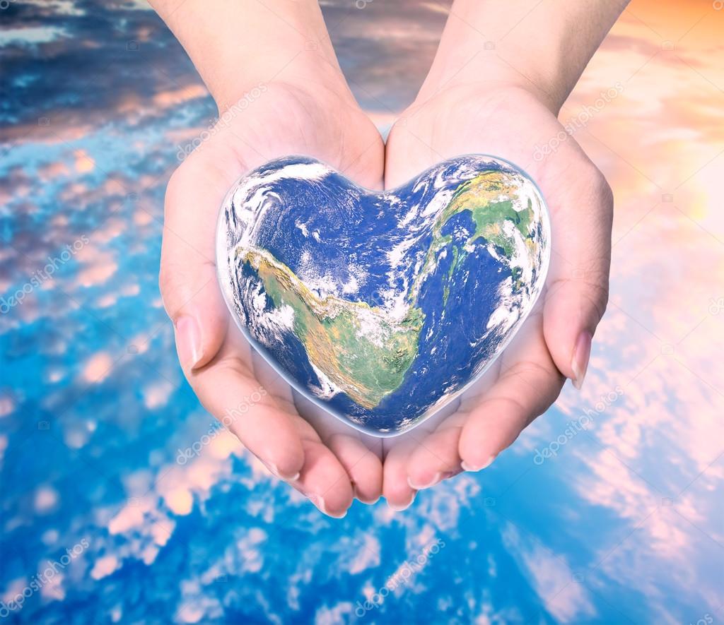 Mundo en forma de corazón con más de las mujeres manos humanas en natu ...