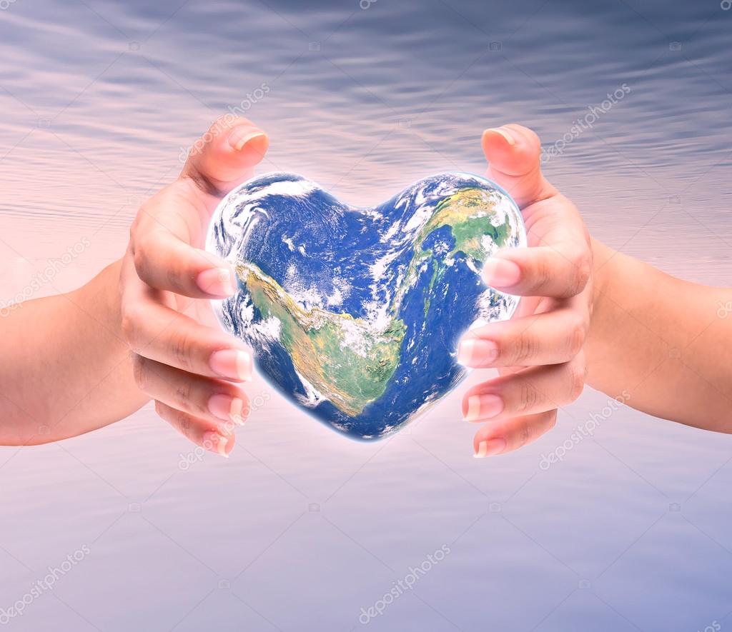 Mundo en forma de corazón con más de las mujeres manos humanas en natu ...