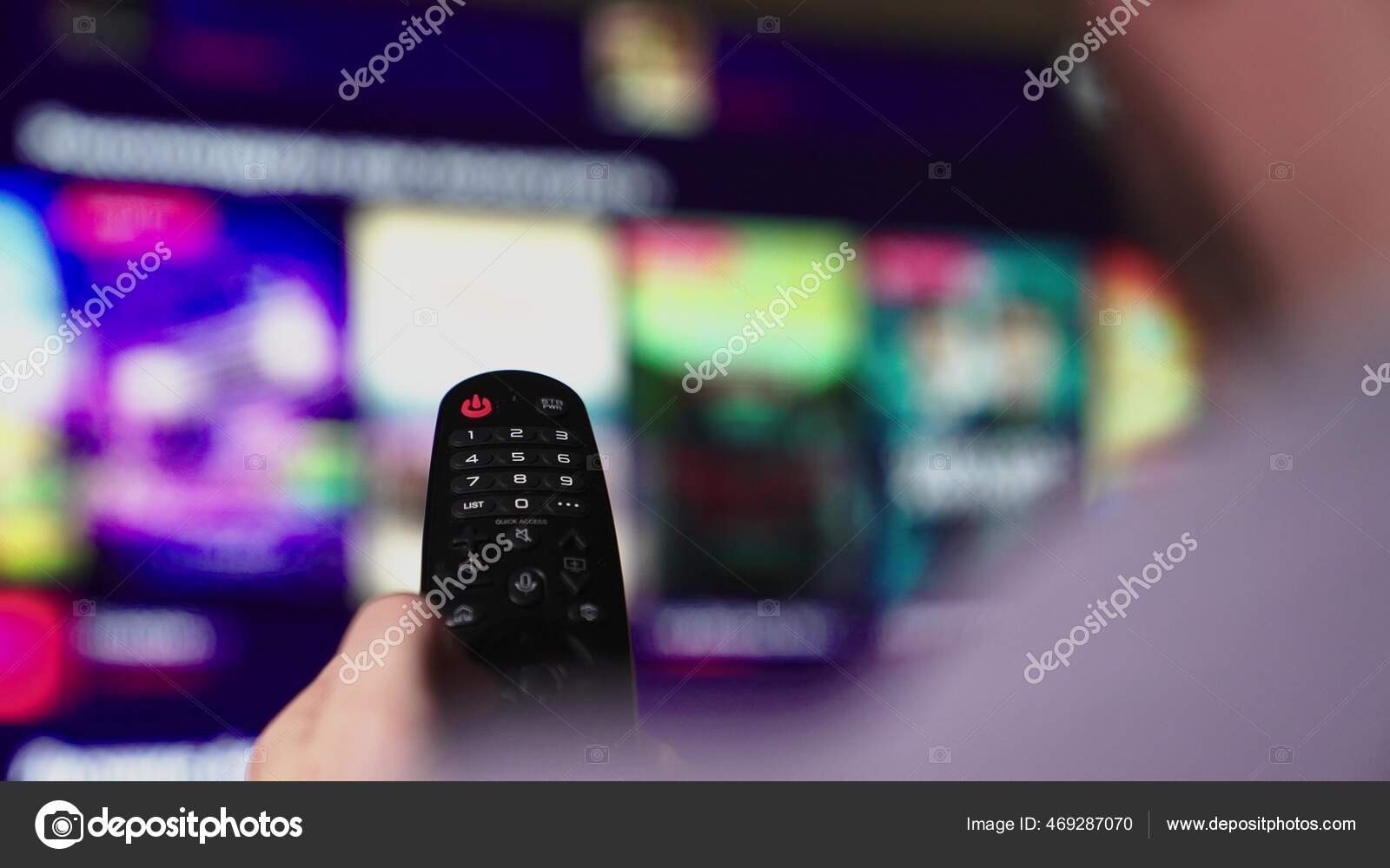 Mans hand selects internet tv channels with remote control, close-up ...